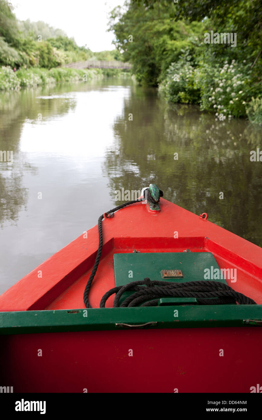 The bow of a barrow boat (barge) with a view up the canal, trees are ...