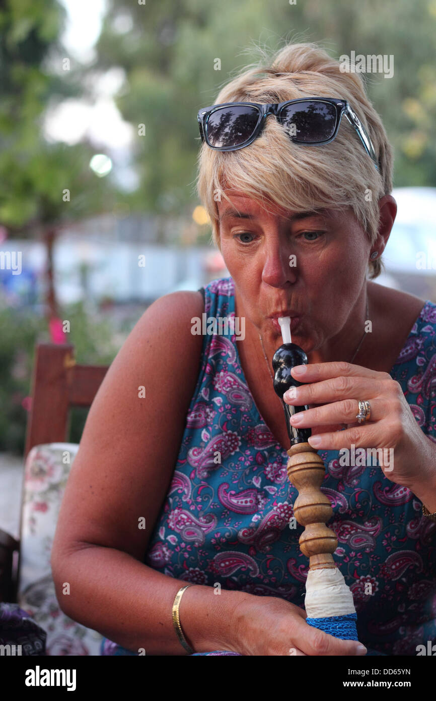 Lady smoking a hookah water pipe Stock Photo - Alamy