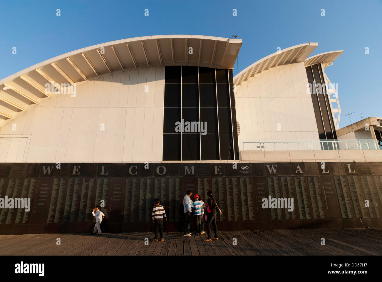 A family looks at the names on the Welcome Wall at the Australian ...