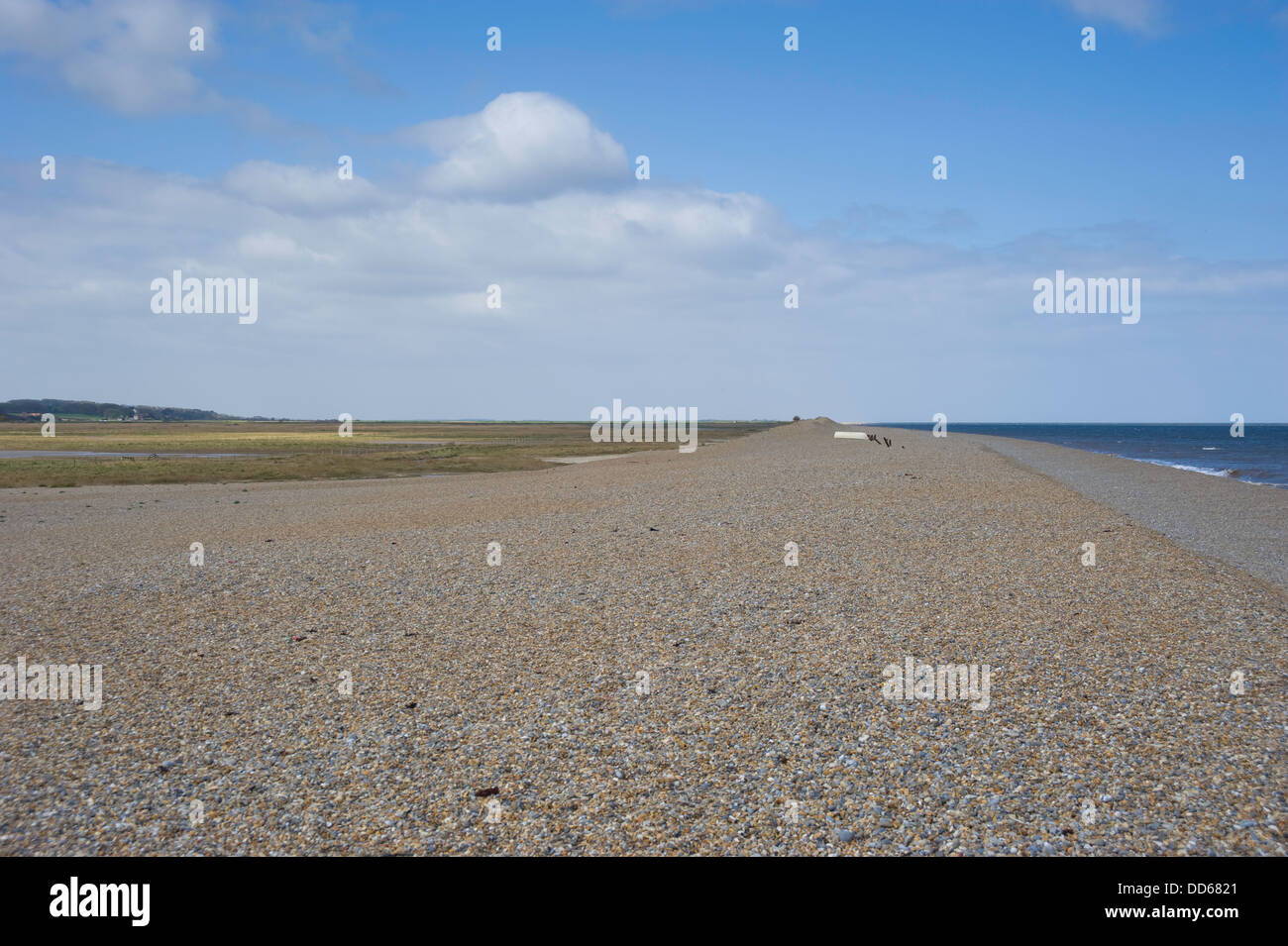Shingle beach and sea defenses with waves lapping the shore at Cley ...