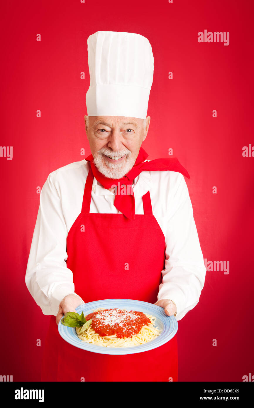 Handsome Italian chef cooks spaghetti marinara. Red background Stock ...