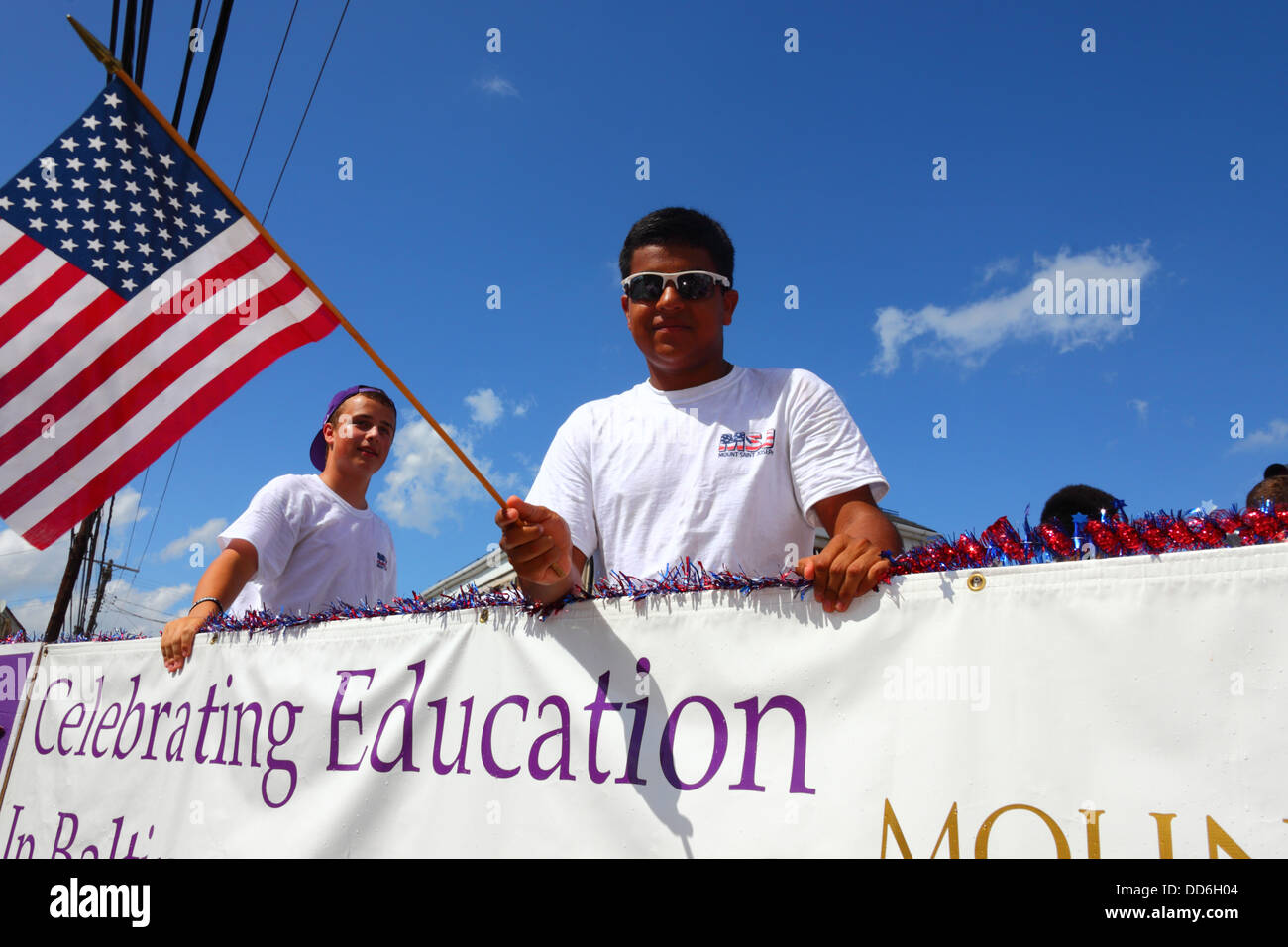 African American boy in college vehicle waving American flag during 4th ...