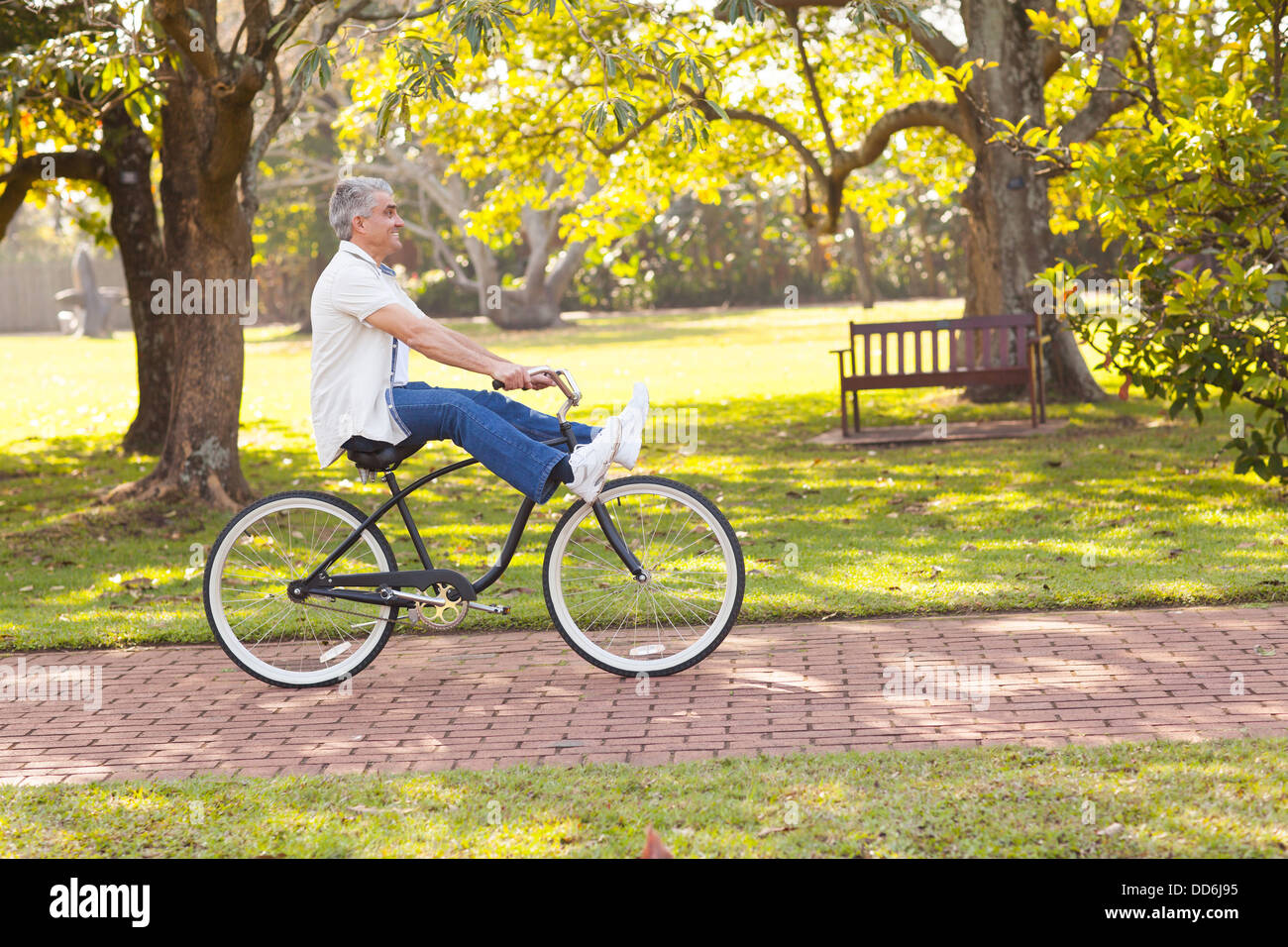 playful senior man riding bicycle at the park Stock Photo - Alamy