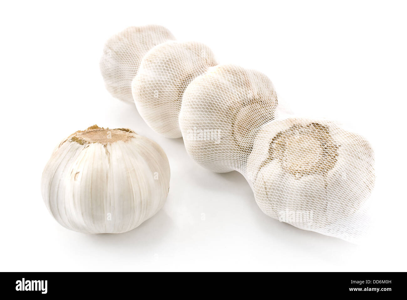 Garlic bulbs in net isolated on white Stock Photo - Alamy