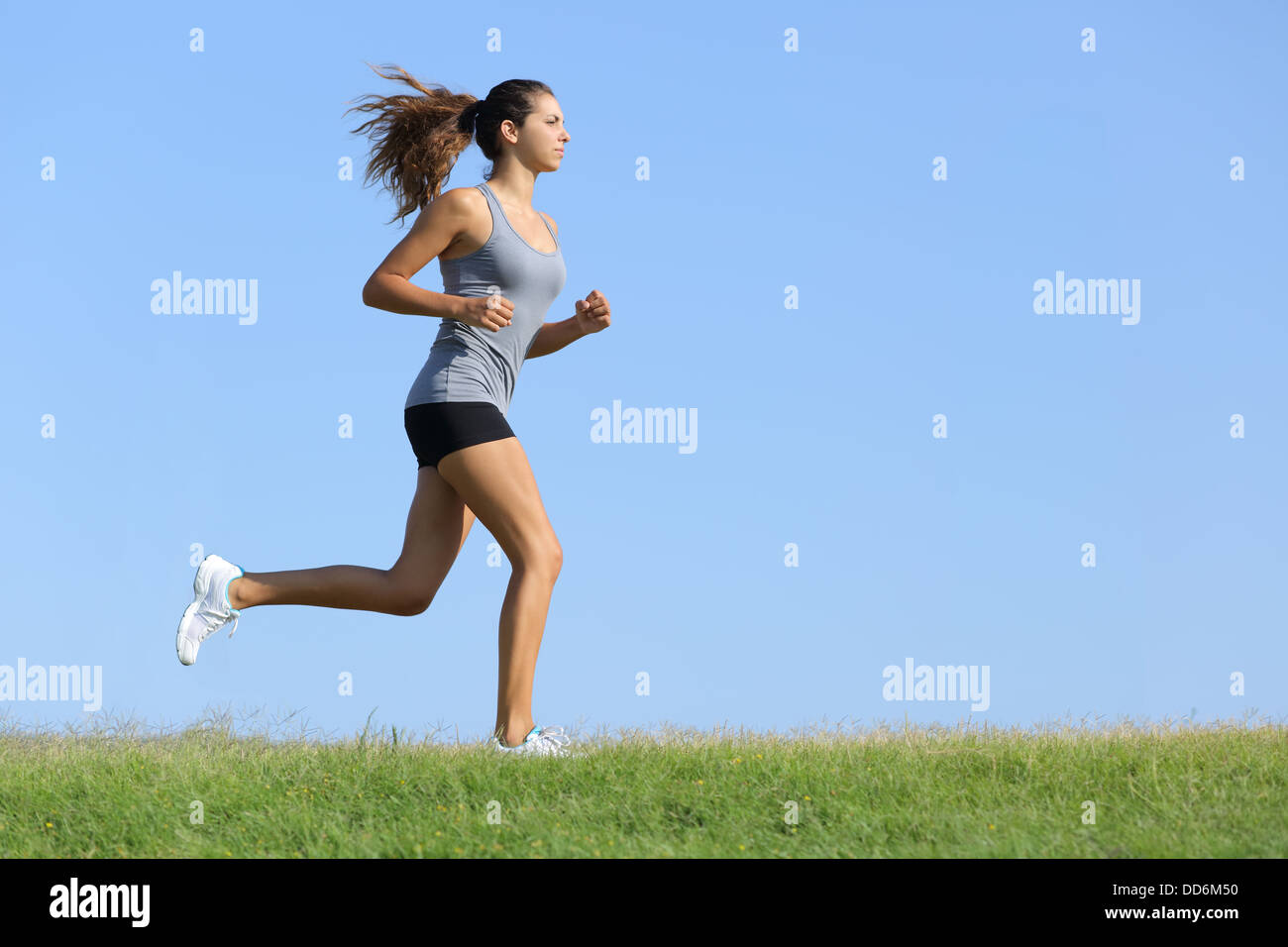 Beautiful woman running on the grass with the sky and the horizon in ...