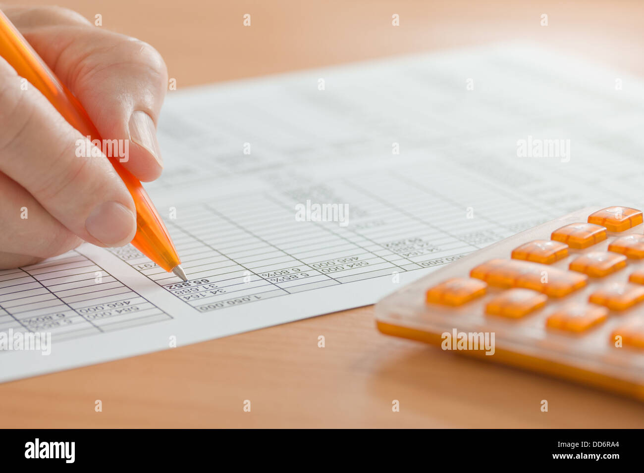 Hand with Orange Pen and Calculator Analyzing Spreadsheet Figures Stock ...