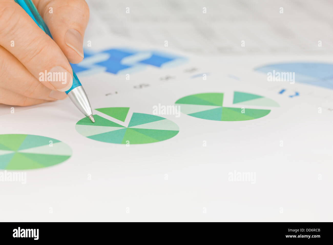 Hand with Pen working on Graphs and Pie Chart Stock Photo - Alamy