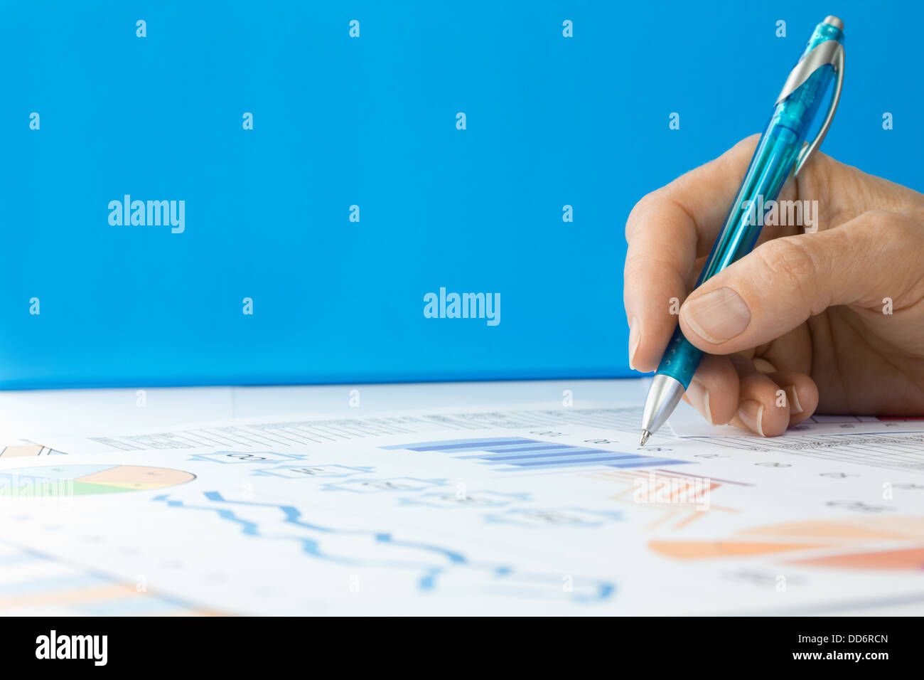 Hand with Pen working on Graphs Stock Photo - Alamy