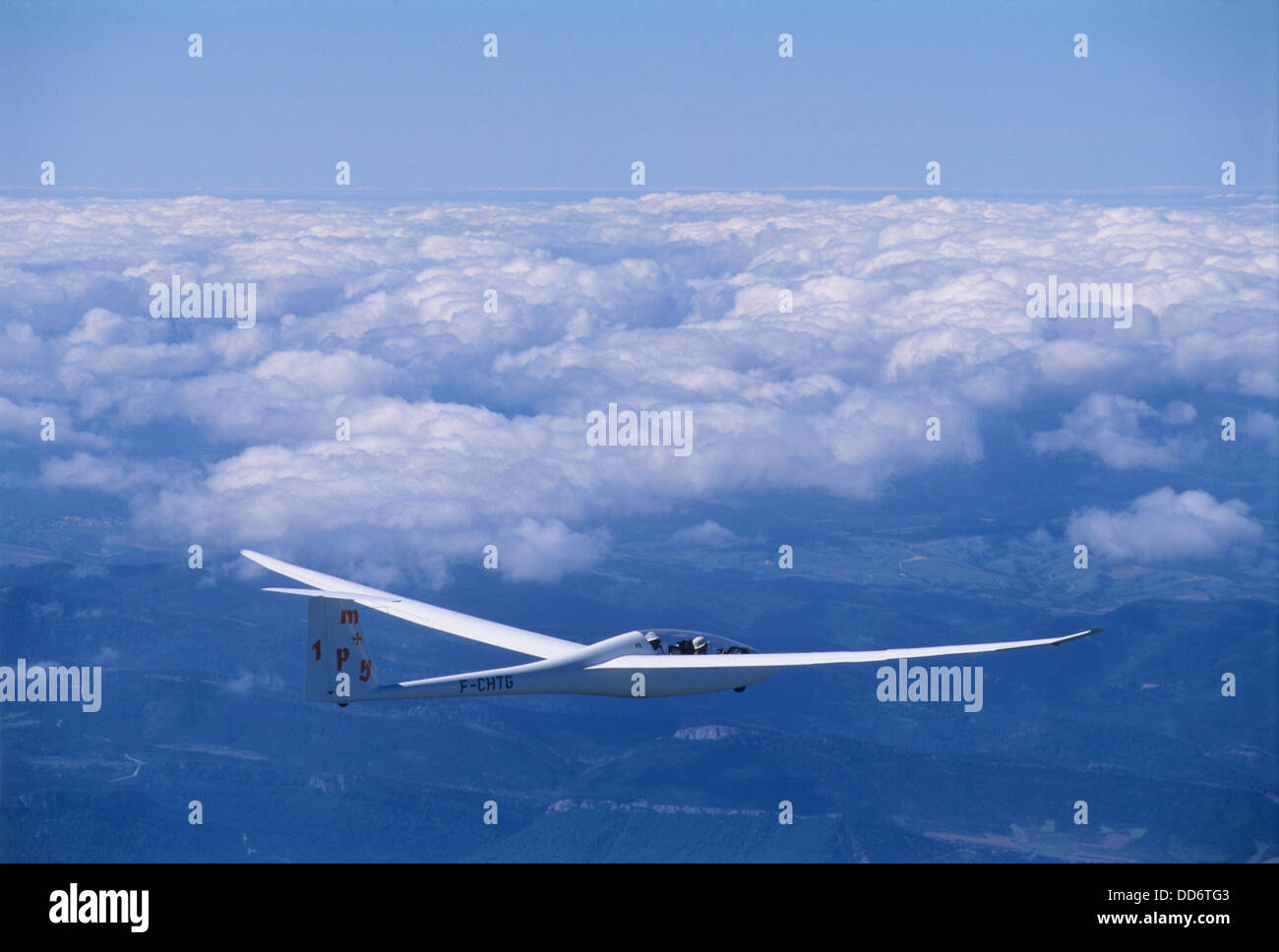 Glider plane Duo Discus flying over clouds in wave flight near Jaca ...