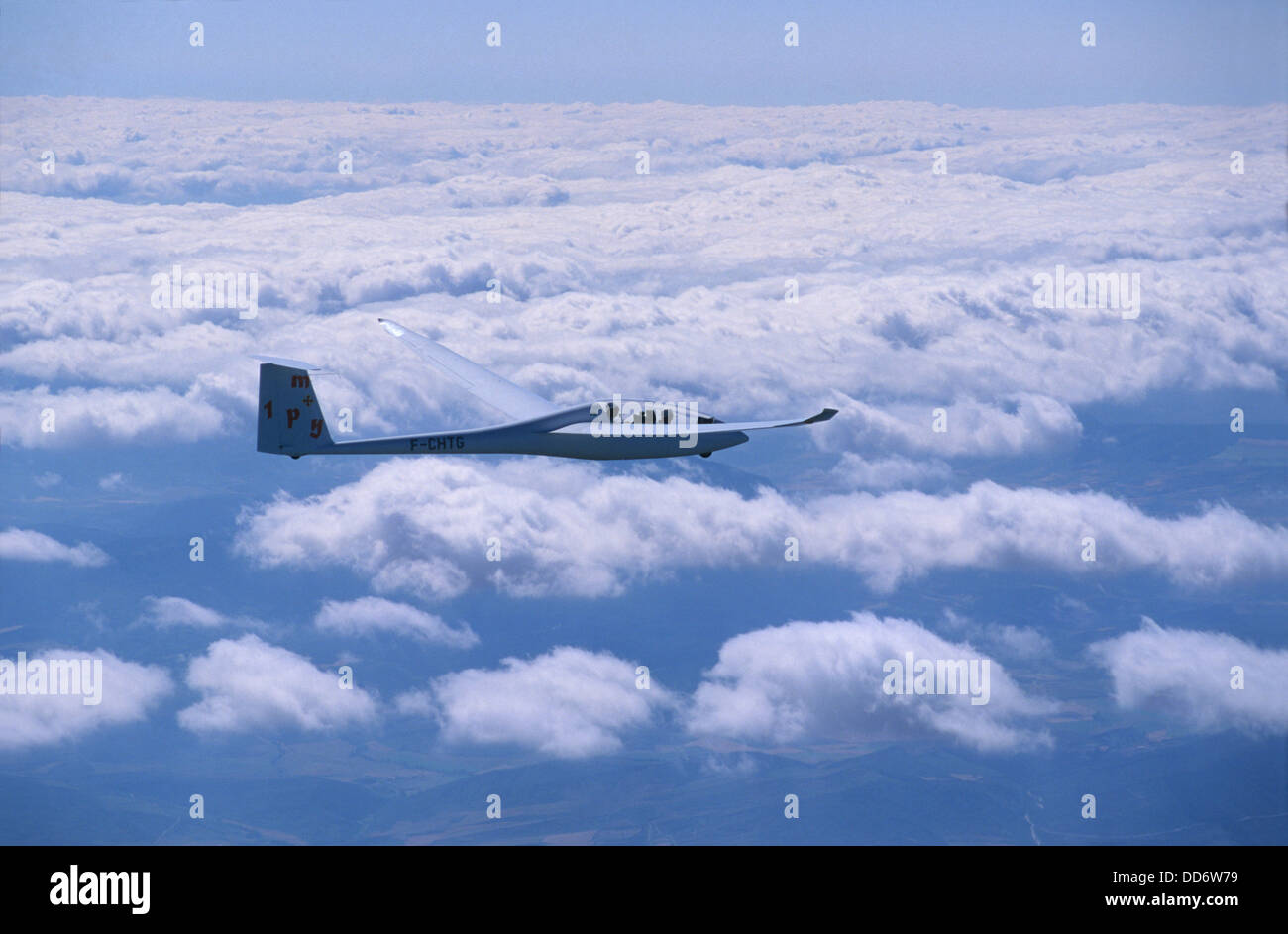 Glider plane Duo Discus flying over clouds in wave flight near Jaca ...