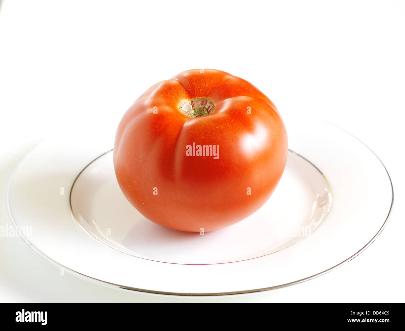 Riped tomato on the white plate Stock Photo - Alamy