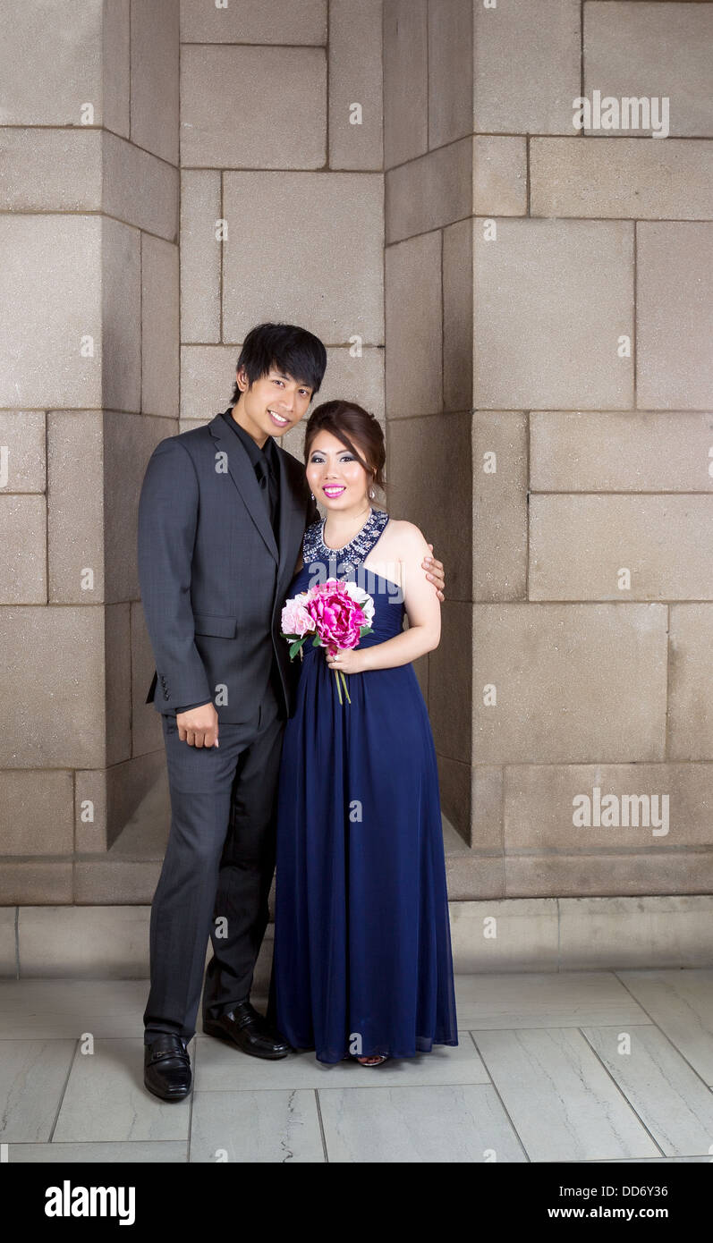 Vertical Photo Of Young Adult Couple Holding Each Other As They Look