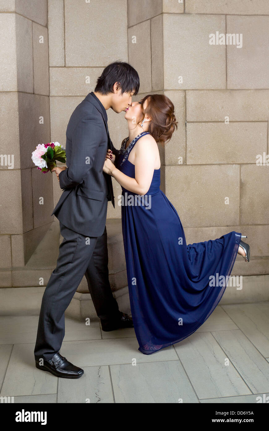 Vertical photo of young adult woman pulling the tie of her man and ...