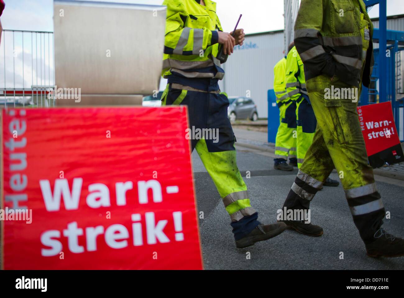Port workers go past a warning strike sign during a strike action at ...