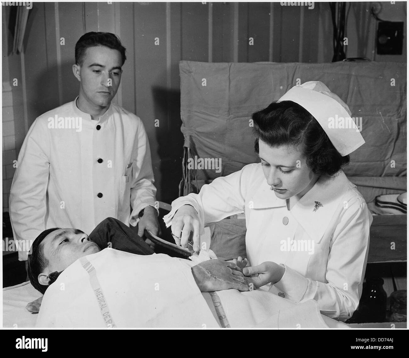 2nd Lieutenant Frances Bullock is seen applying a dressing to a soldier ...