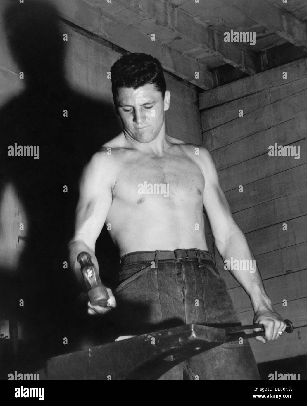 CCC enrollee forging a piece of steel in a CCC blacksmith shop. 1930s ...