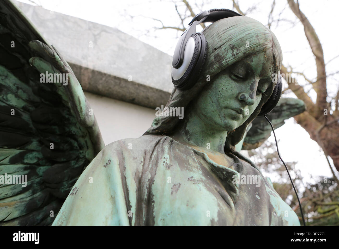 Germany, Cologne, Angel statue with headphones in cemetery Stock Photo ...