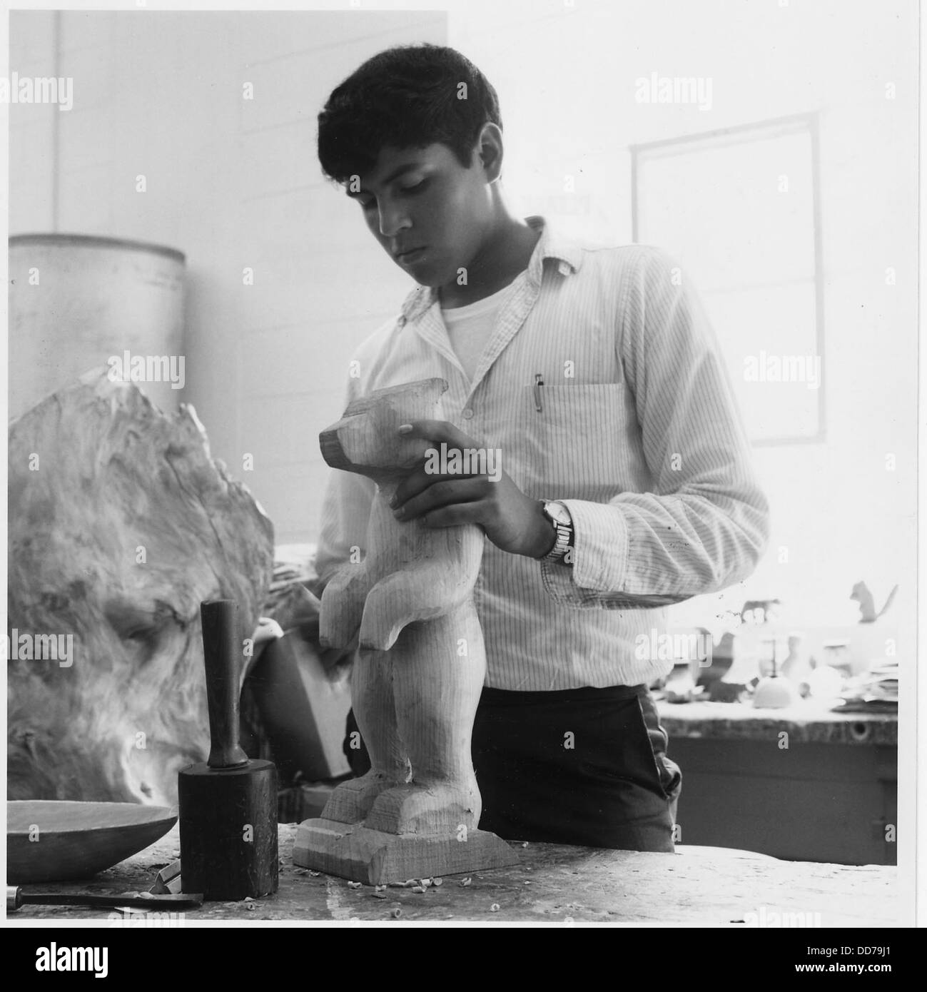 Image of Cherokee craftsman Jessie Saunlooke carving a bear figure. The ...