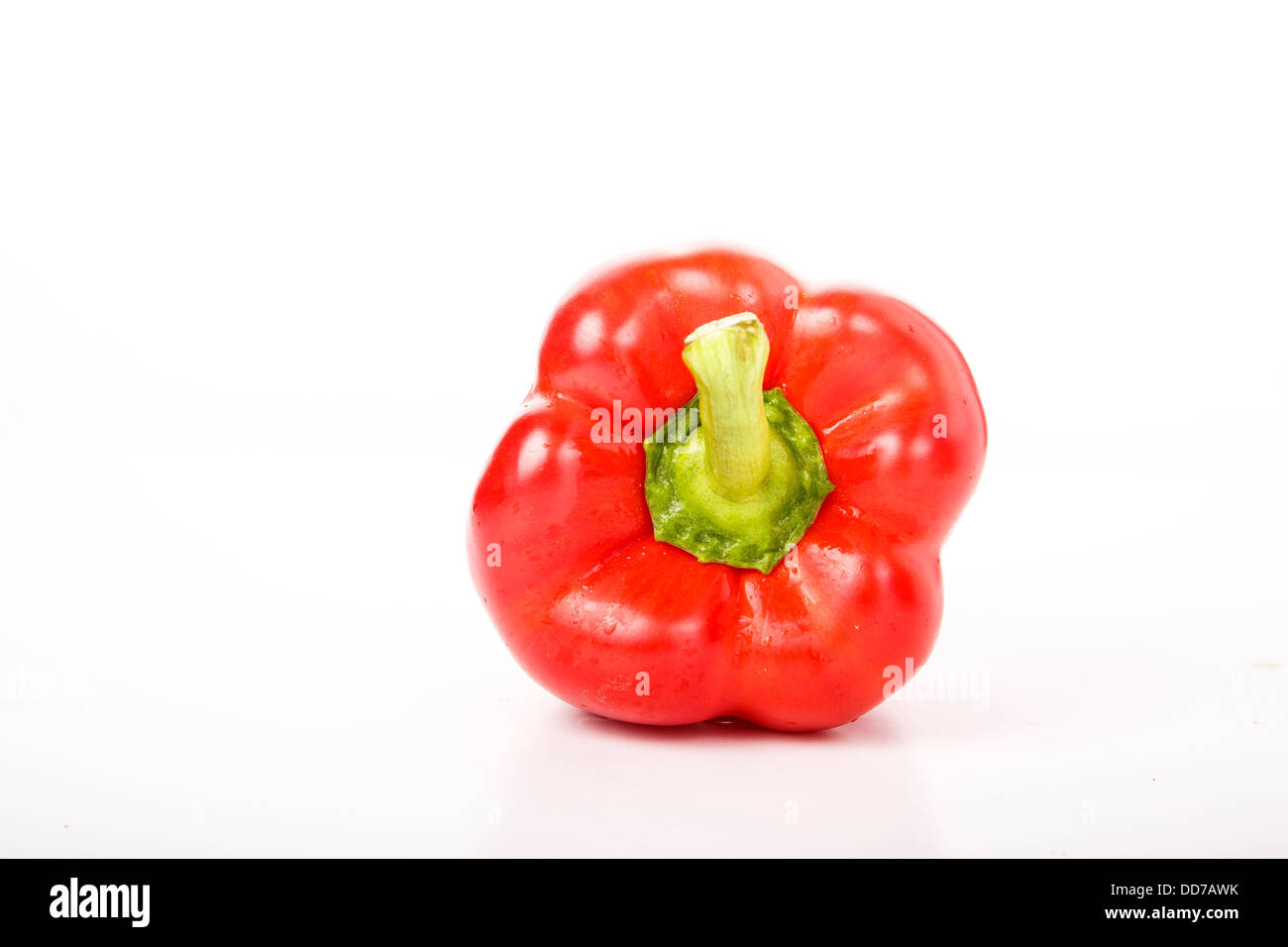 A single red bell pepper on a white background Stock Photo - Alamy