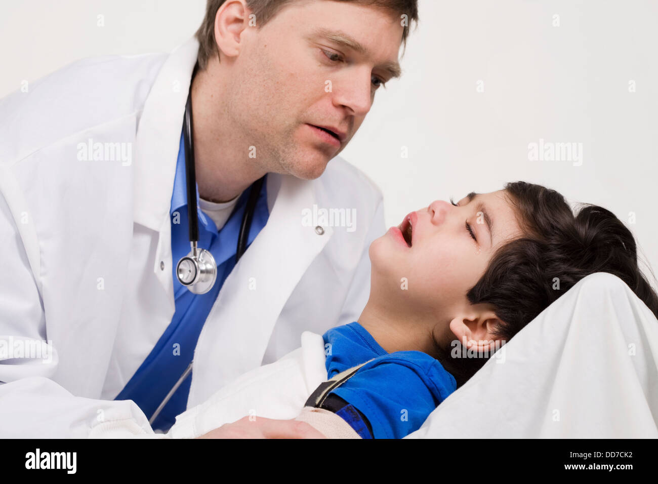 Male doctor comforting disabled toddler patient. Child is five years ...