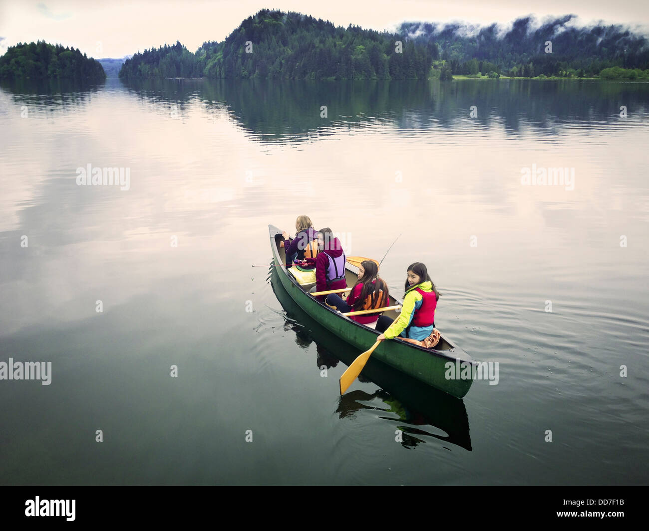 Girls rowing canoe in lake Stock Photo - Alamy