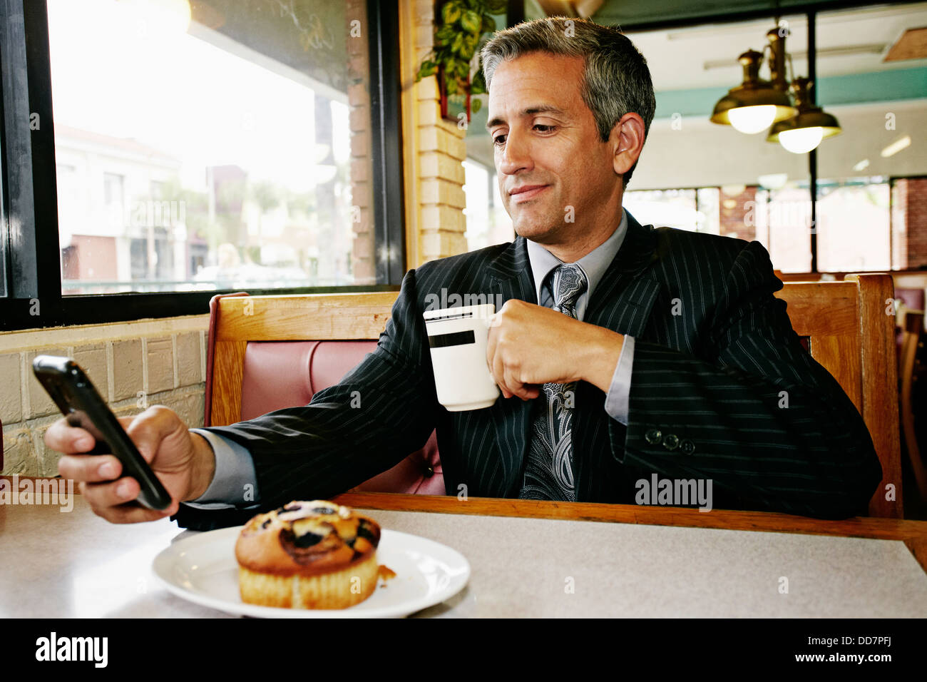 Hispanic businessman using cell phone in restaurant Stock Photo - Alamy