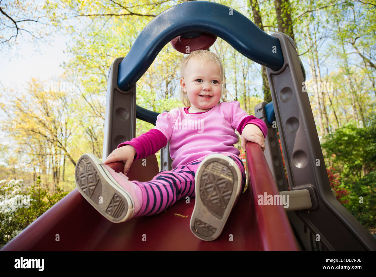 Caucasian girl playing on slide outdoors Stock Photo - Alamy