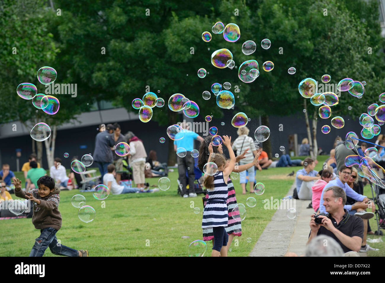 Children having fun with soap bubbles in London at the river Thames ...