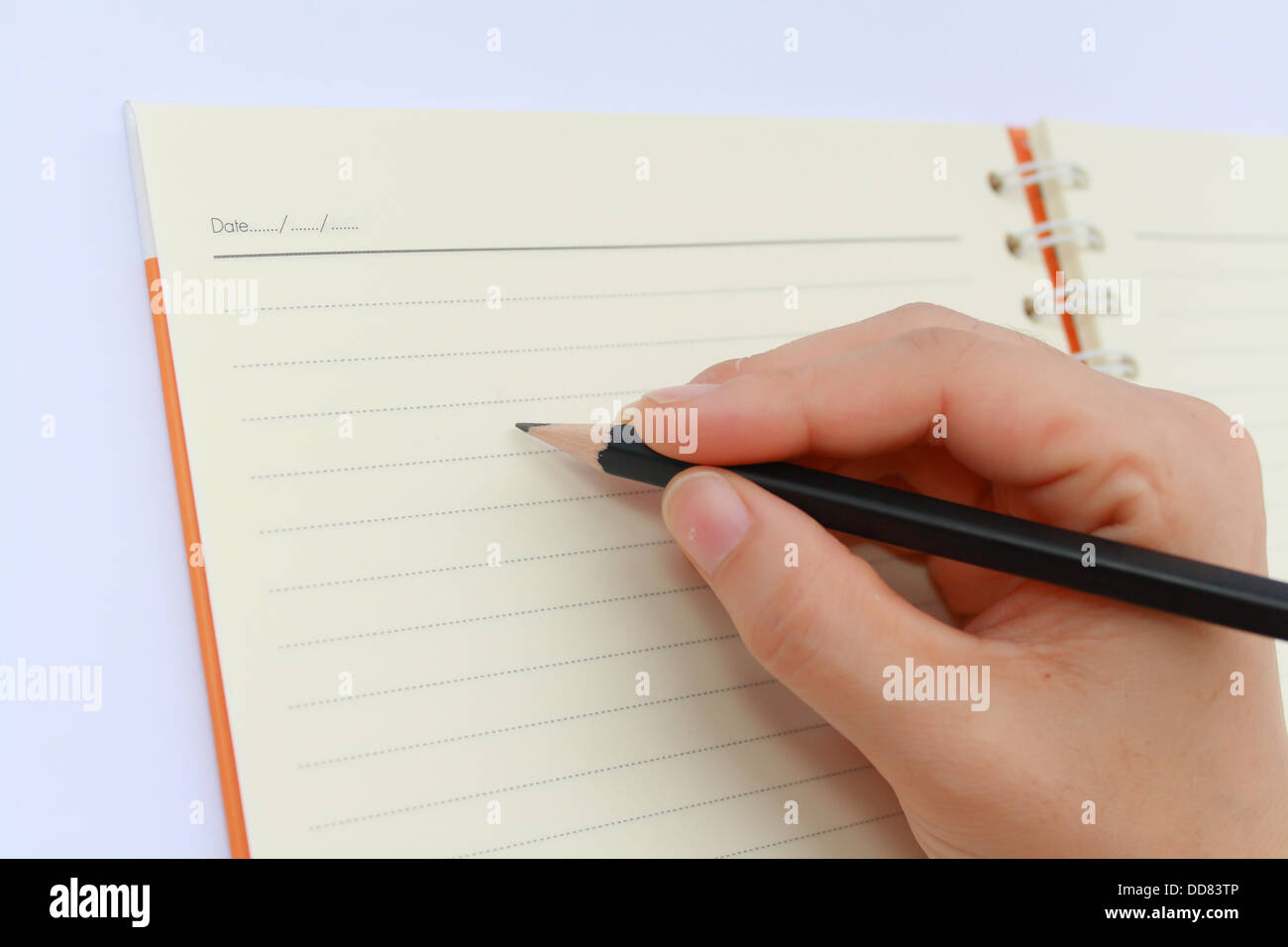 a hand with pencil writing on a notebook Stock Photo - Alamy
