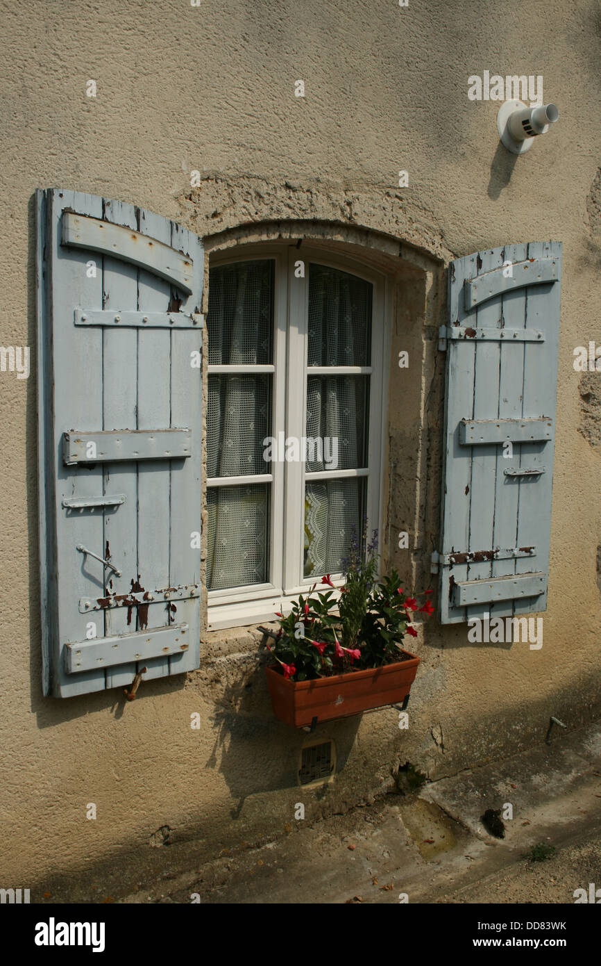 Typical blue French arch window shutters with flowers in window box ...