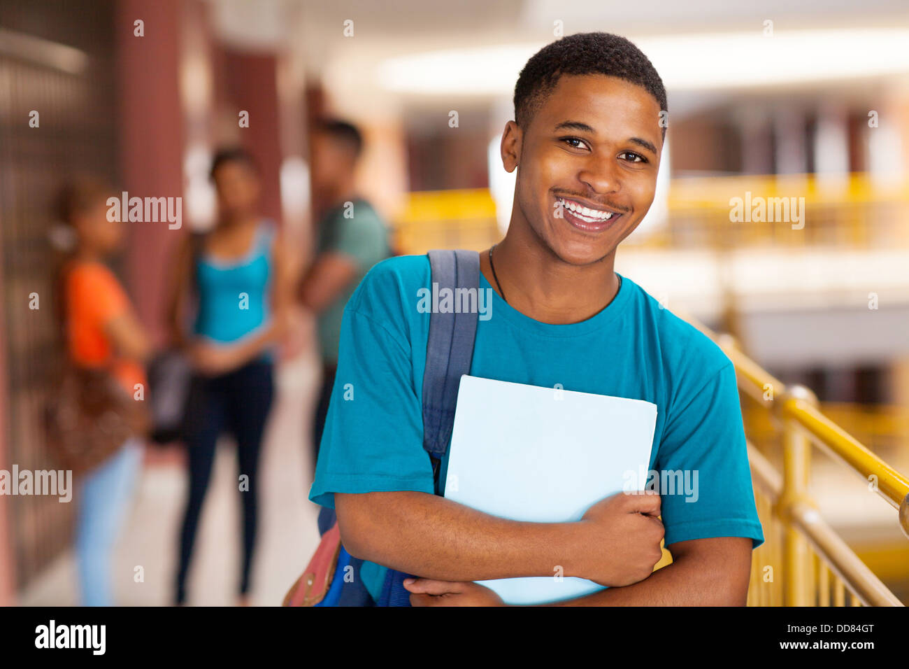 handsome young college boy holding books on campus Stock Photo - Alamy