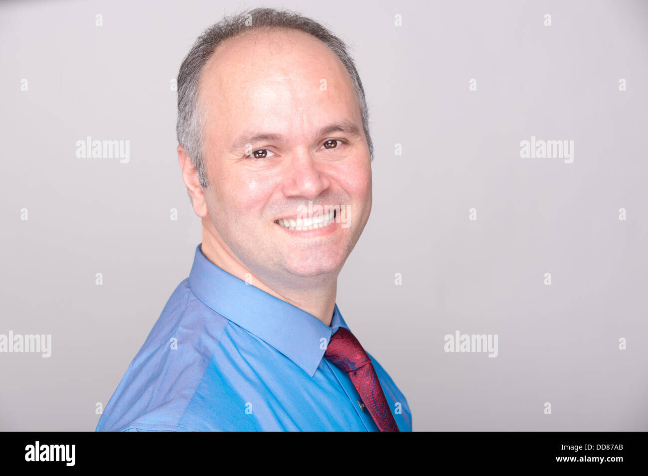 A middle age office worker smiling to the camera with his blue shirt ...