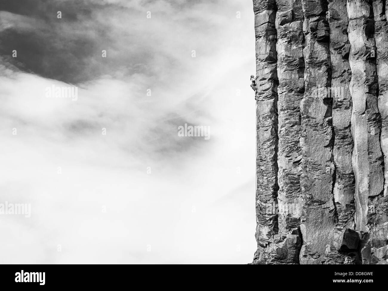 A woman climbing a basalt rock cliff in central Washington State, USA ...