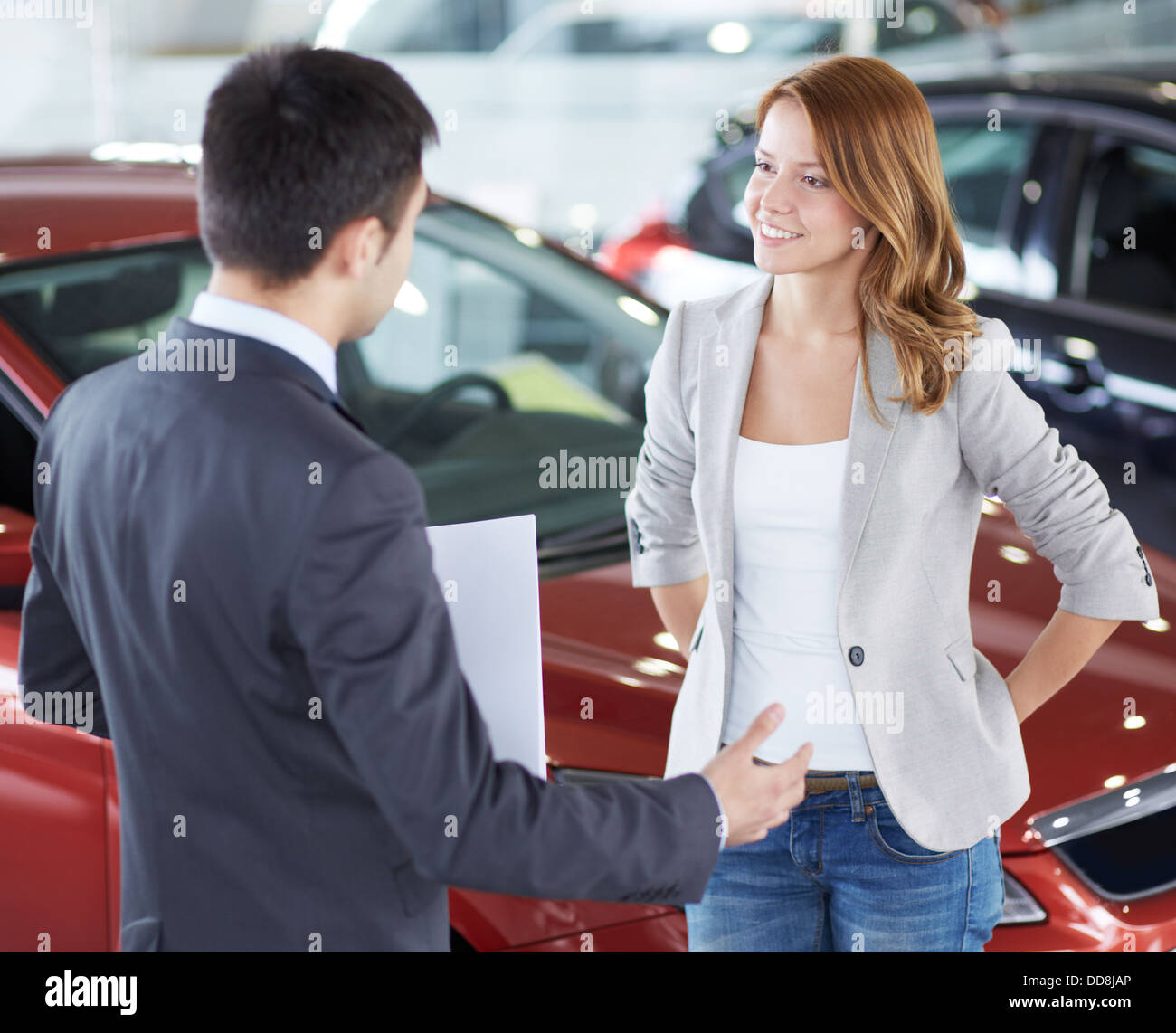 Image of car dealer and happy female communicating in automobile center ...