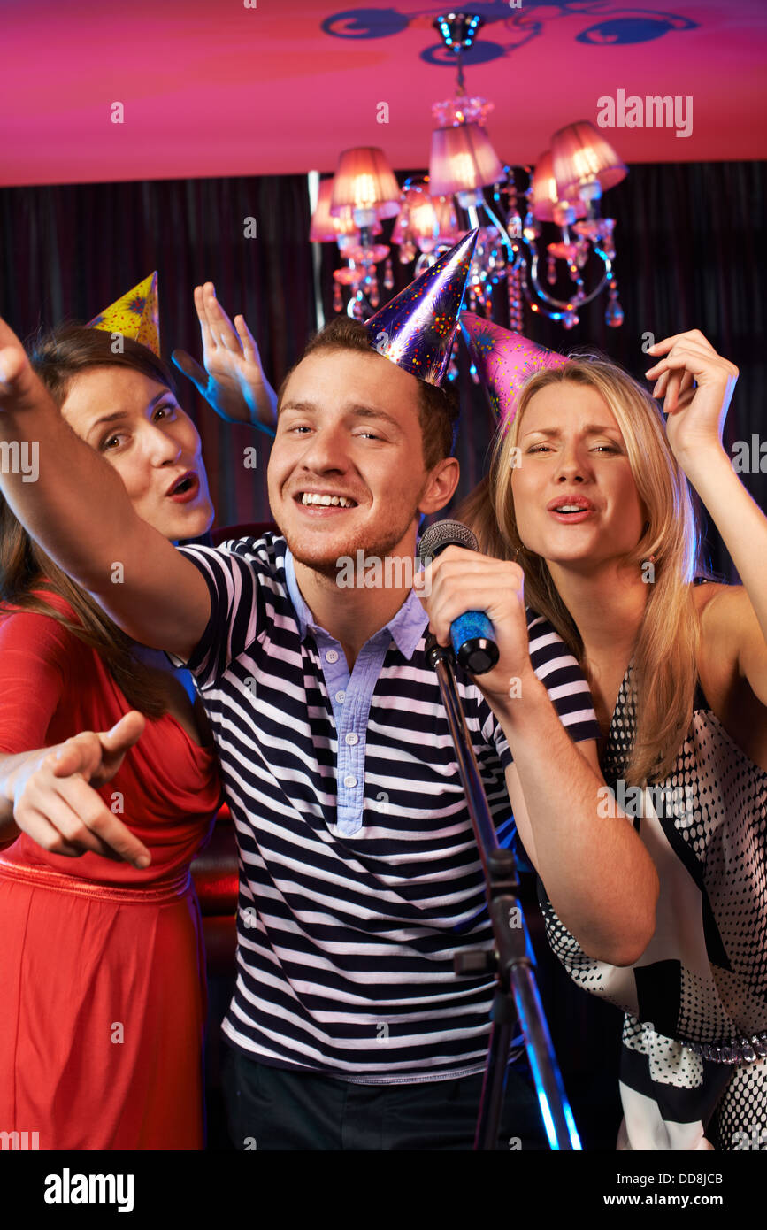 Portrait of happy people singing in microphone in the karaoke bar Stock ...