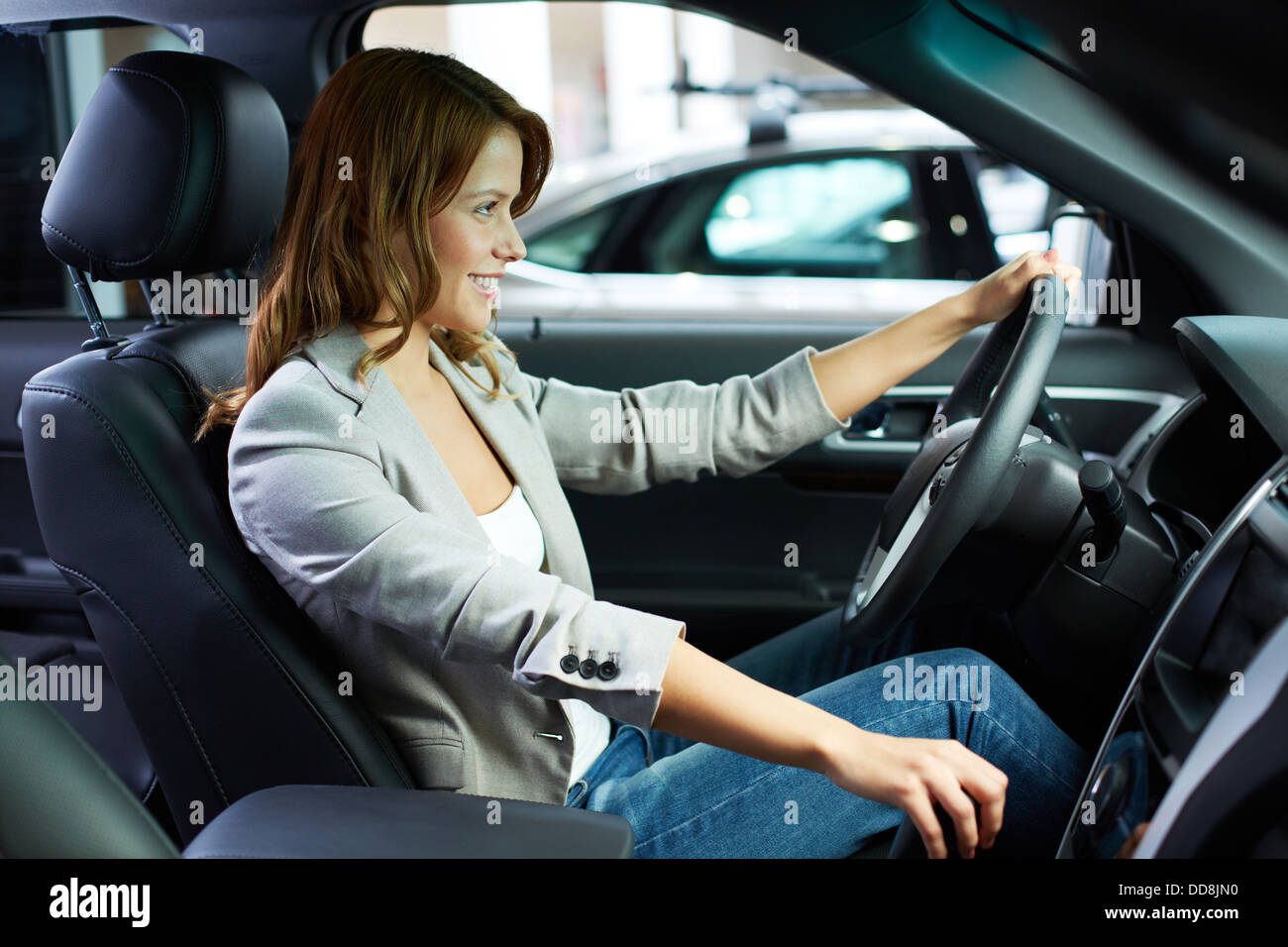 Cheerful young woman learning to drive on her own Stock Photo - Alamy