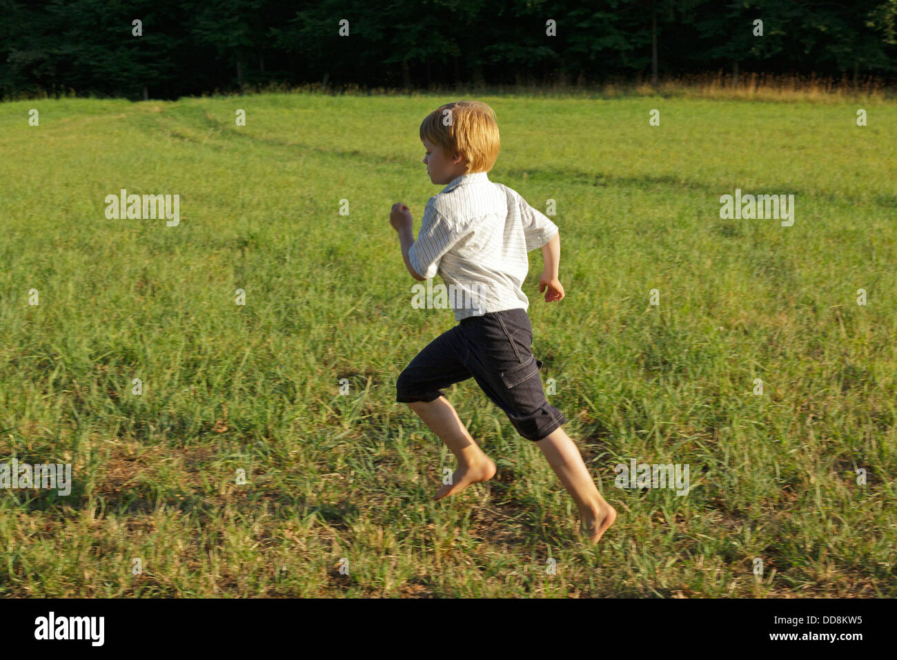 Boy Running Across Grass Stock Photos & Boy Running Across Grass Stock ...