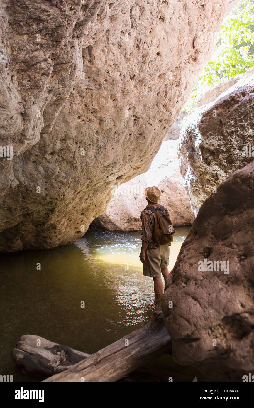 Caucasian man looking up at rock formation Stock Photo - Alamy