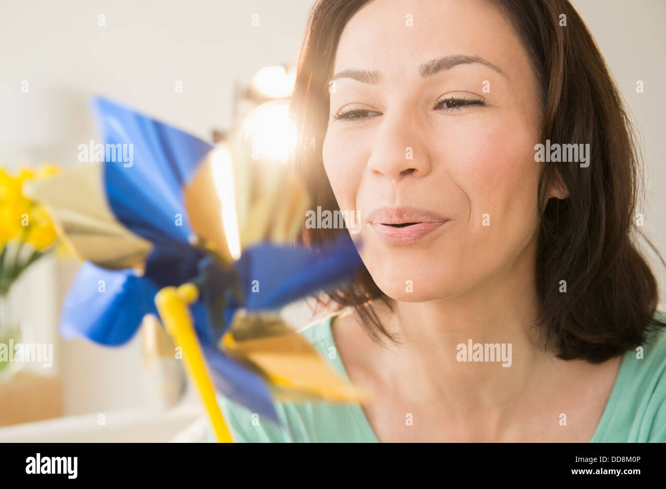 Caucasian woman blowing pinwheel Stock Photo - Alamy