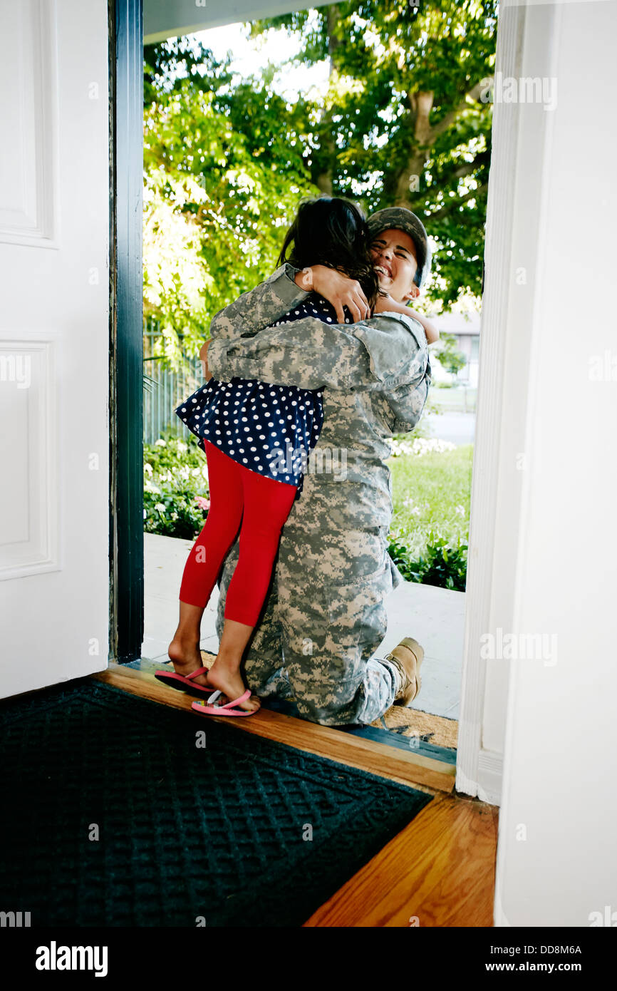 Mixed race soldier mother hugging daughter in front door Stock Photo ...