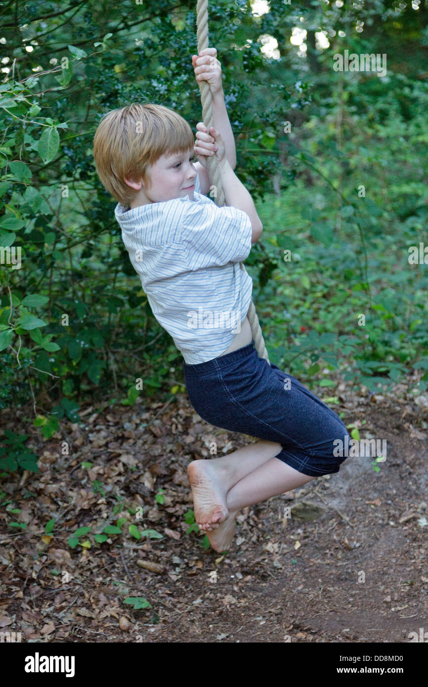 young boy swinging on a rope Stock Photo - Alamy