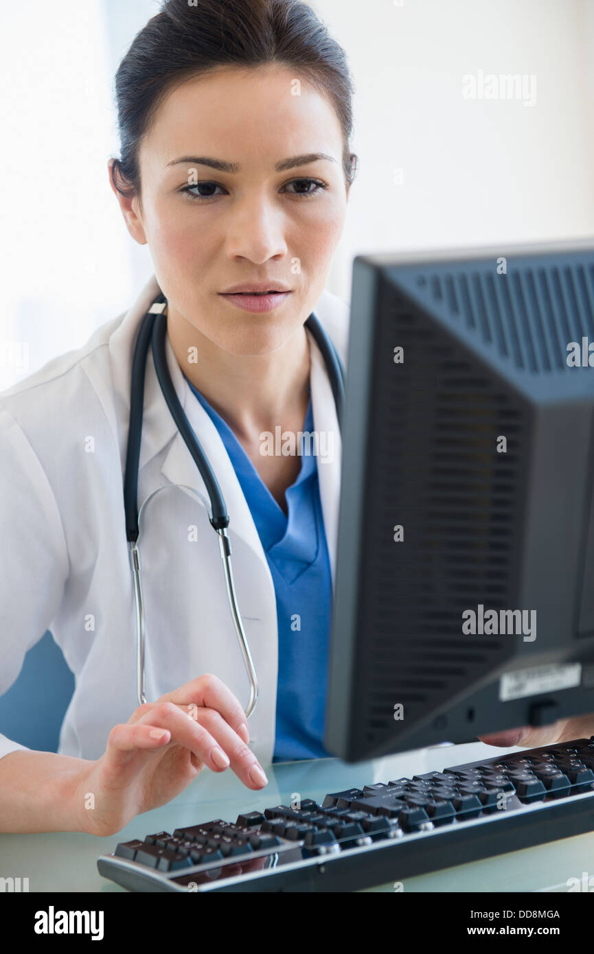 Caucasian doctor using computer at desk Stock Photo - Alamy