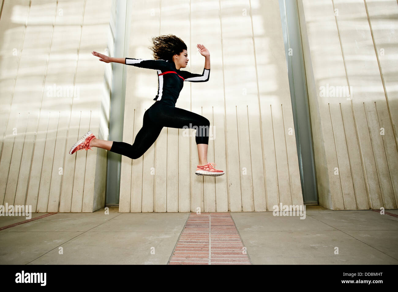 Mixed race woman running on city street Stock Photo - Alamy