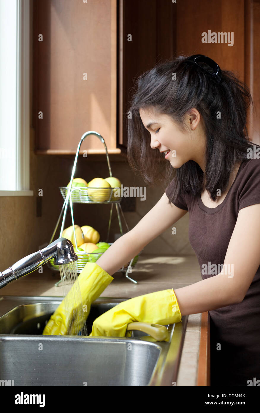 Teen girl washing dishes at kitchen sink Stock Photo - Alamy