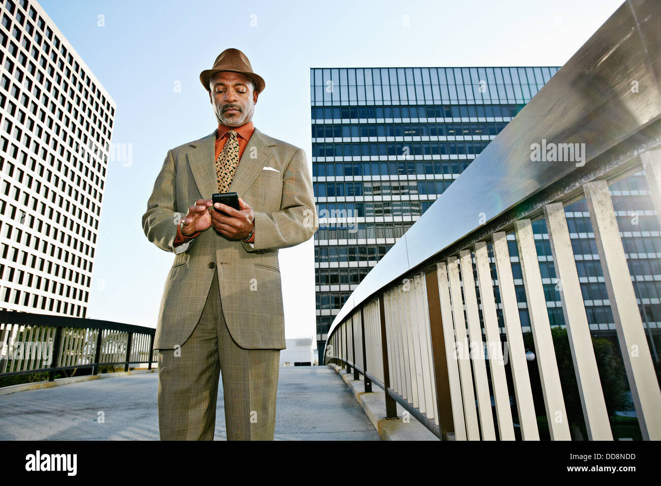 Black businessman using cell phone on urban walkway Stock Photo - Alamy