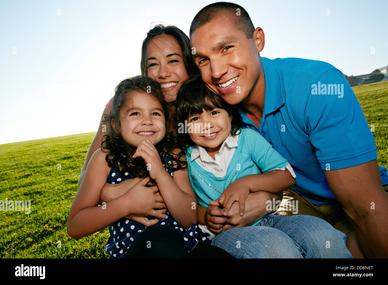 Family smiling together in field Stock Photo - Alamy