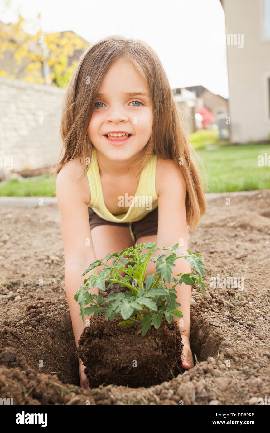 Caucasian girl planting in backyard Stock Photo - Alamy