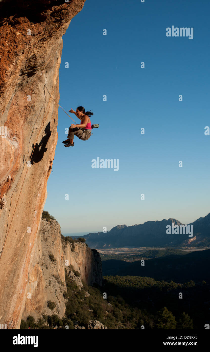 Side view of female sport climber. Adult woman is falling down during ...