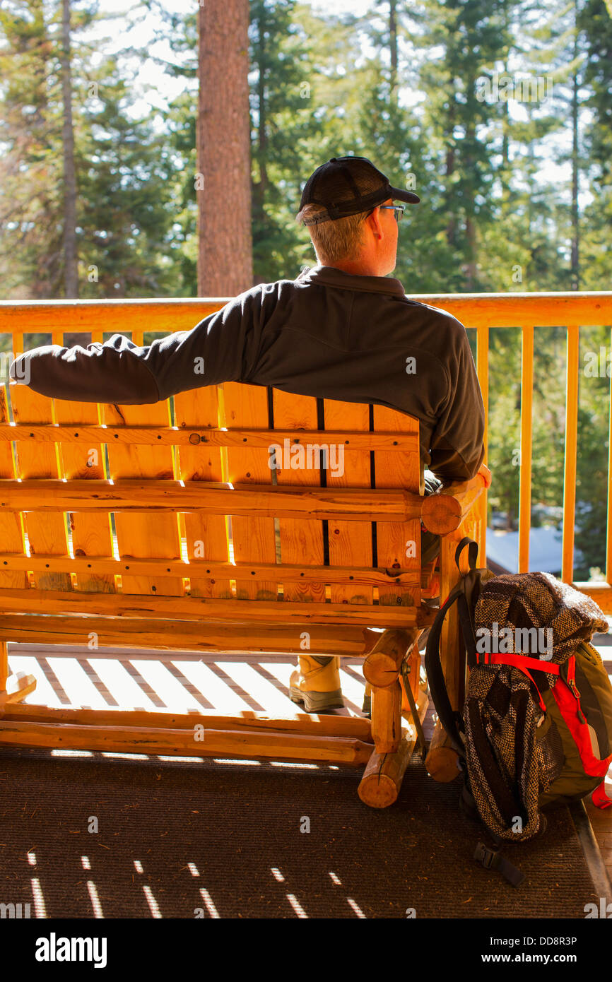 Caucasian man sitting on wooden bench Stock Photo - Alamy