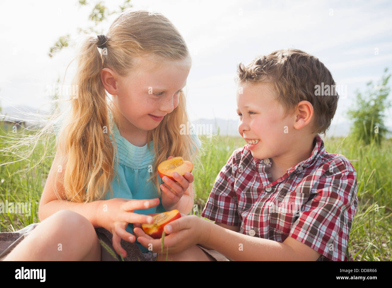 Caucasian children sharing fruit outdoors Stock Photo - Alamy